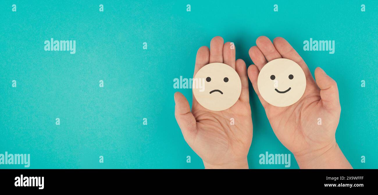 Holding a head with a sad and a happy face in the hands, mental health ...