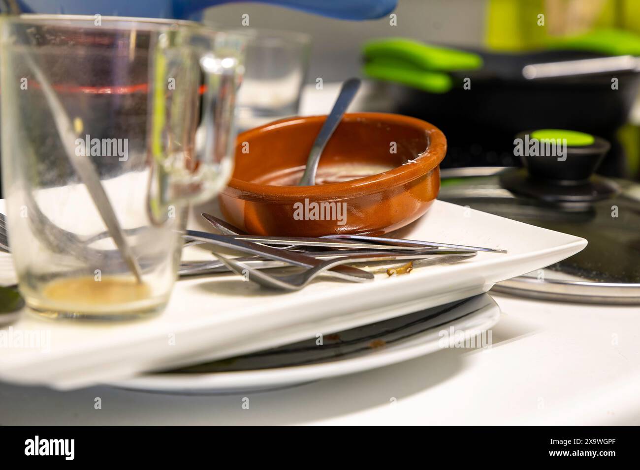 A messy kitchen countertop with dirty dishes and glasses waiting to be ...