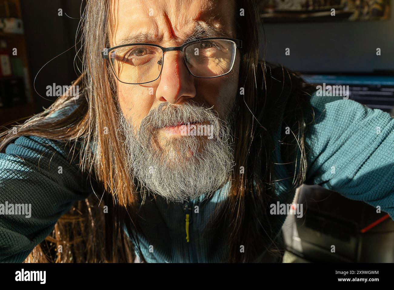 A man with glasses and a beard is looking at the camera. He has a ...