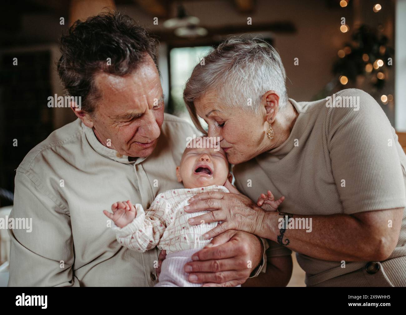 Grandparents holding crying baby girl, calming her down, soothing her ...
