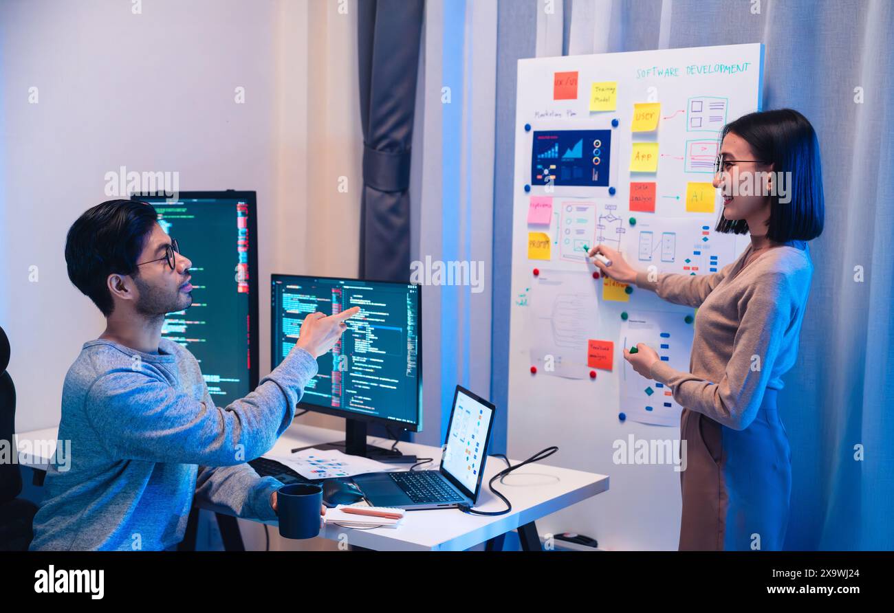 Asian software developers teams working on multiple screens displaying code and application ...