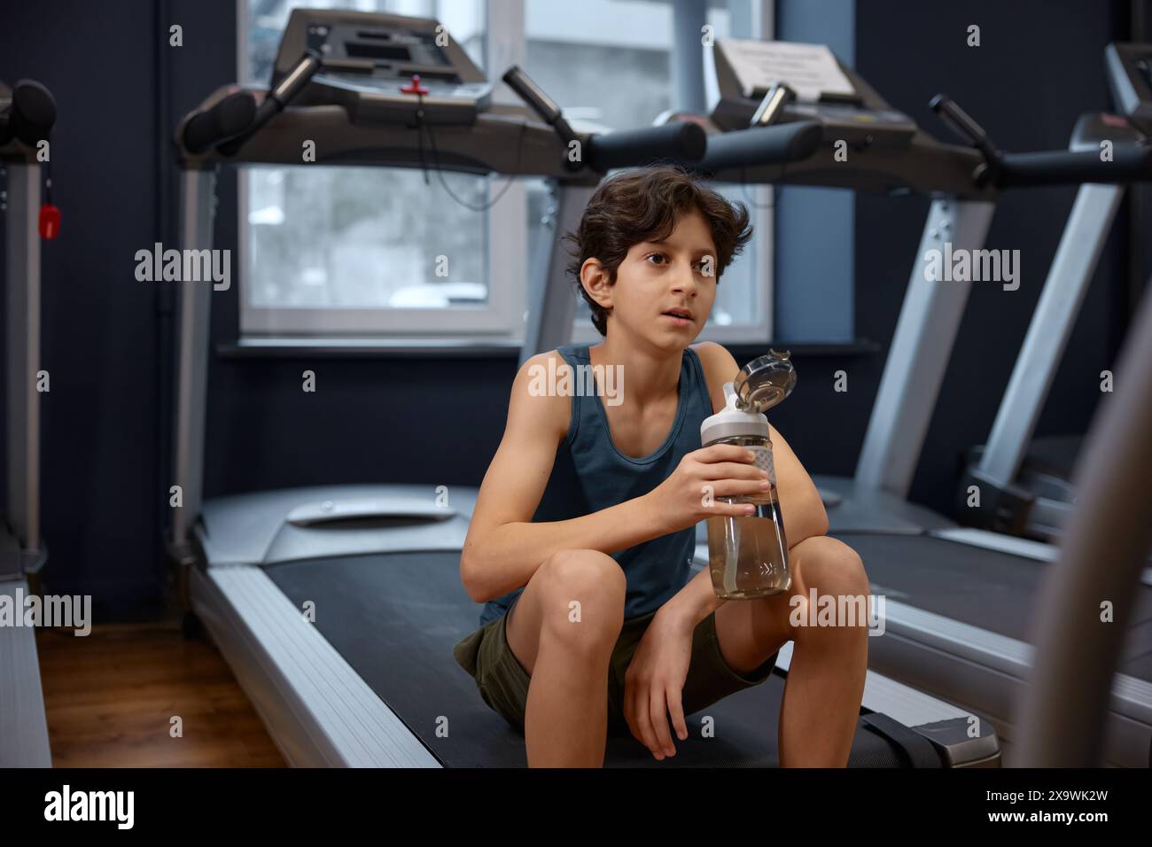 Preteen boy having rest after training on treadmill Stock Photo - Alamy
