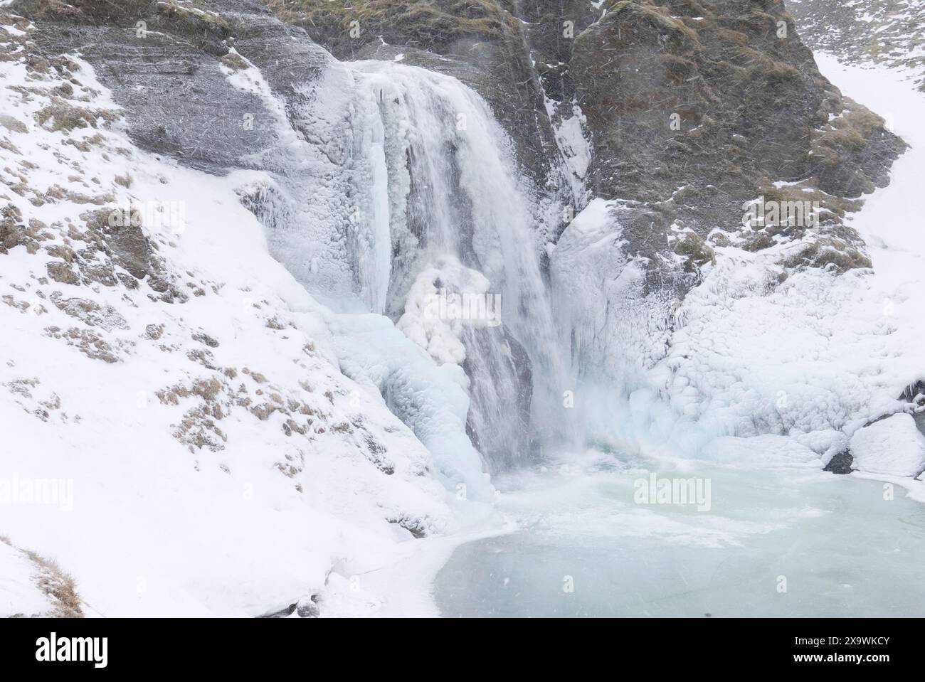 .Helgufoss waterfall covered in ice in early Spring. Iceland Stock ...
