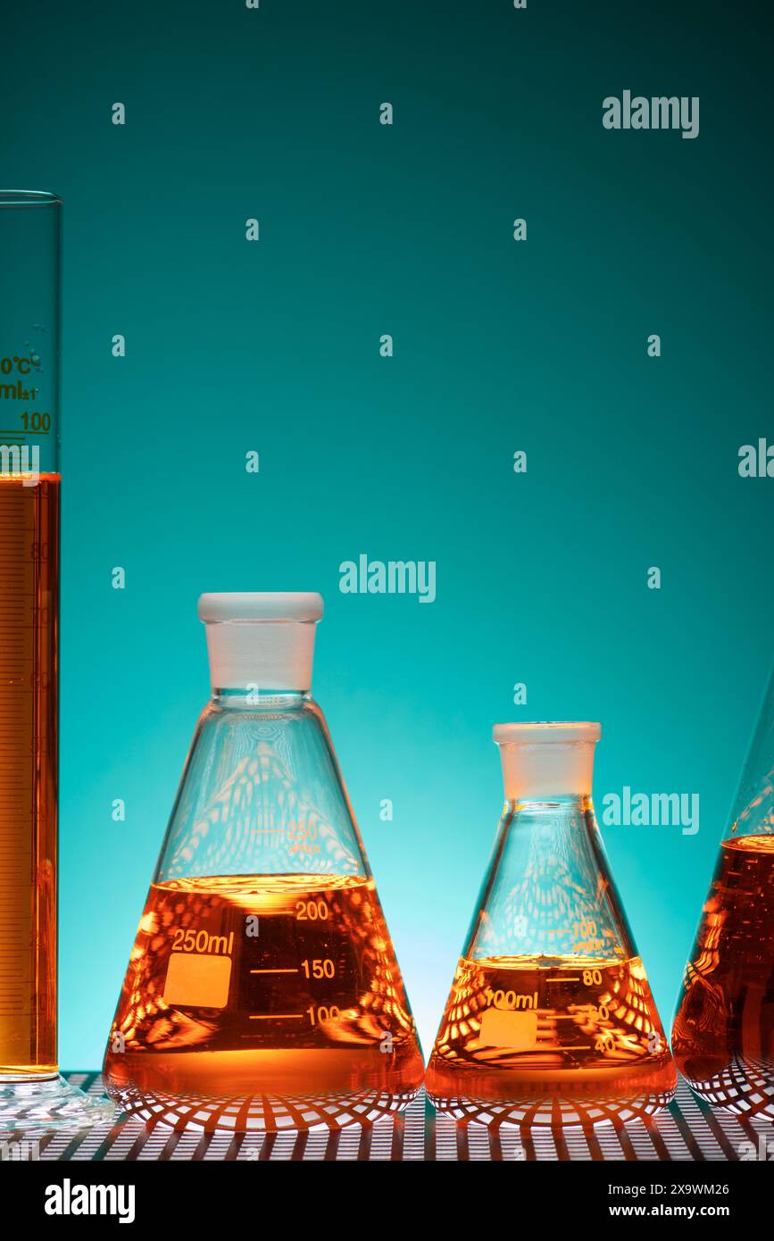 Close up of a glass beakers with orange liquid standing in a laboratory ...