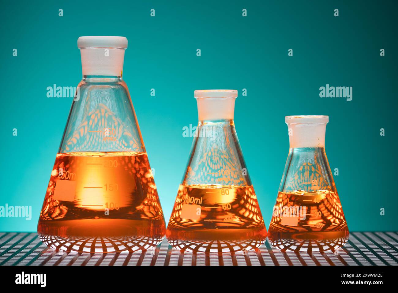 Close up of a glass beakers with orange liquid standing in a laboratory ...