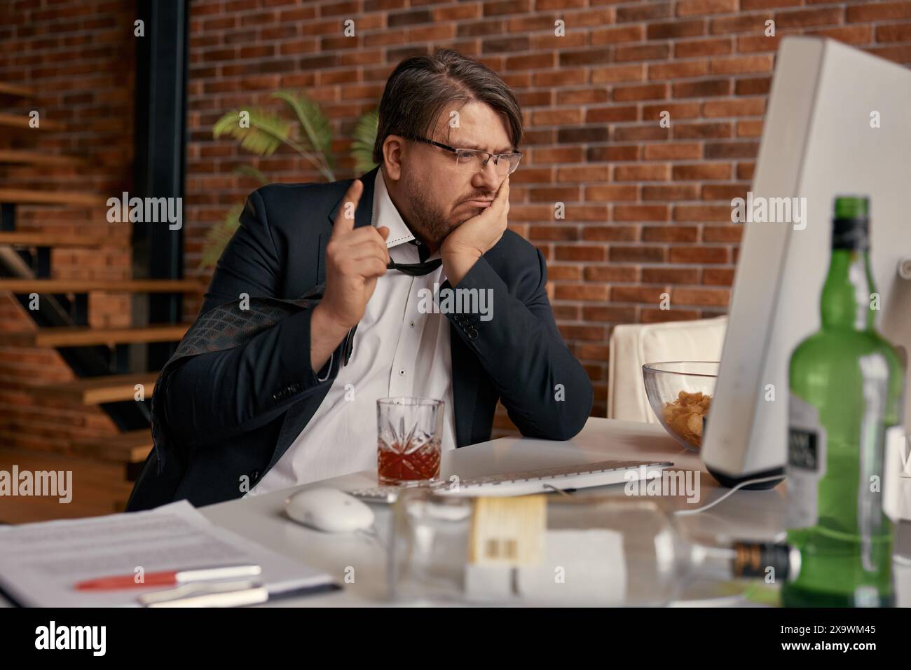 Drunk businessman working online at virtual home office Stock Photo - Alamy