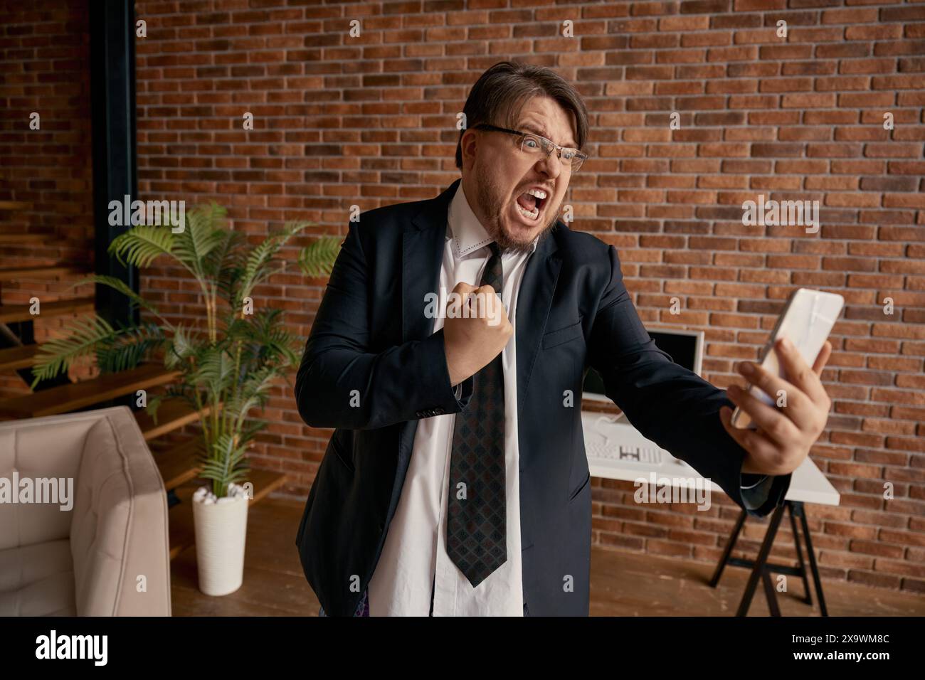 Crazy mad businessman shouting on mobile phone having bad conversation ...