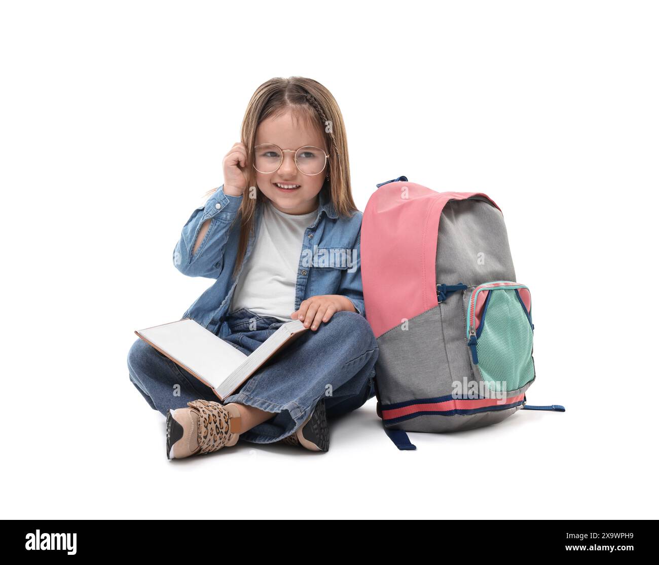 Cute little girl with book and backpack on white background Stock Photo ...