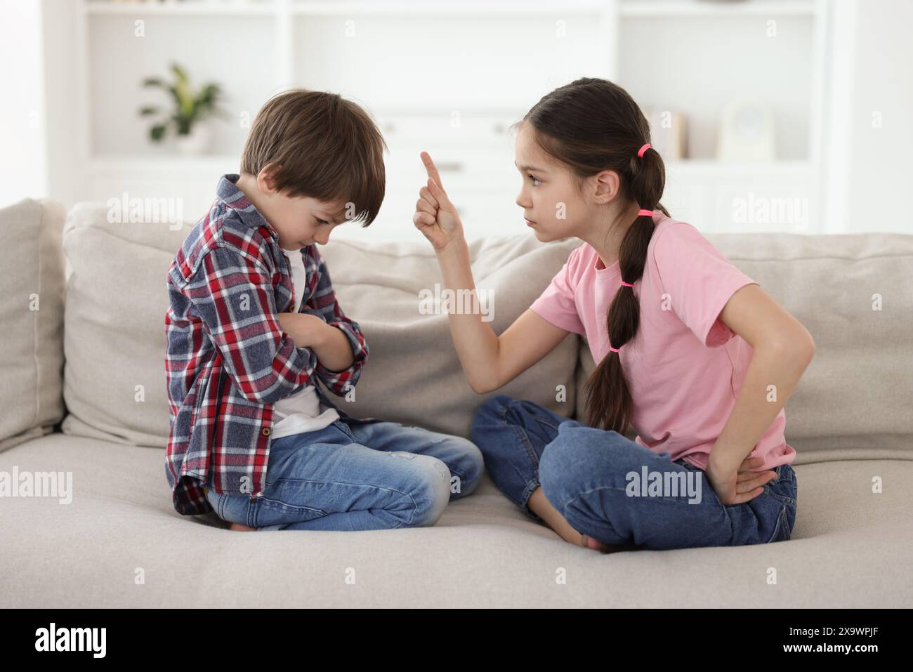 Upset brother and sister having argument on sofa at home Stock Photo ...