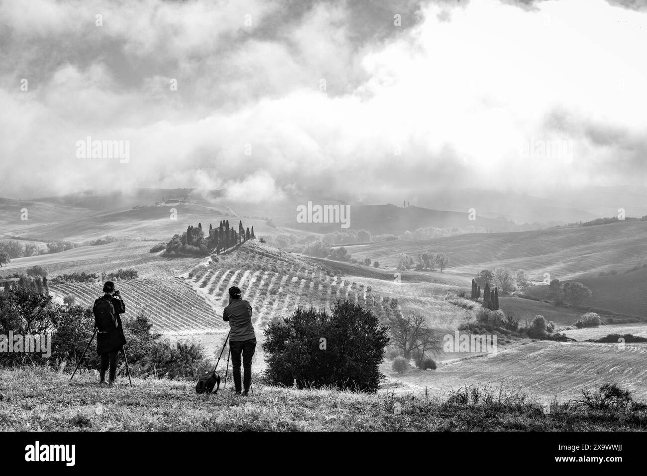 A couple of photographers take photos of Tuscany, Italy. Scenery black ...