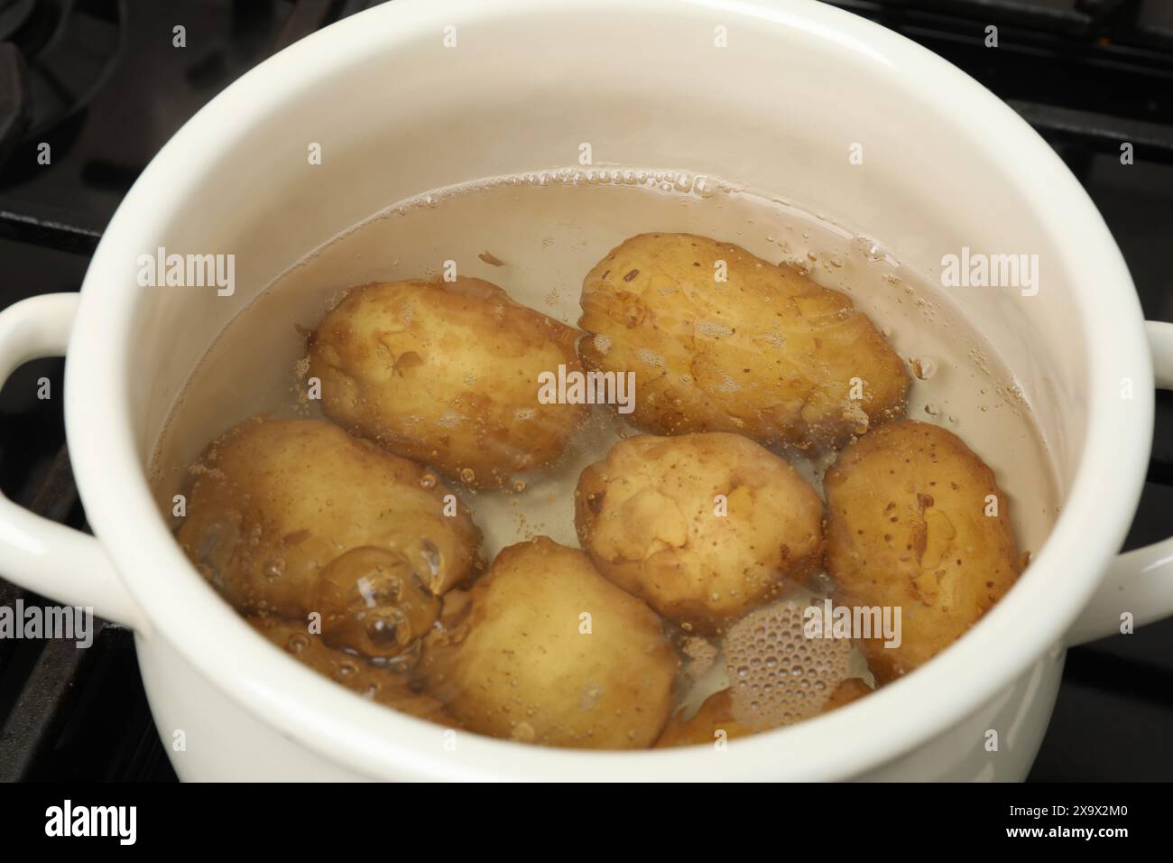 Boiling young potatoes in pot on stove Stock Photo - Alamy