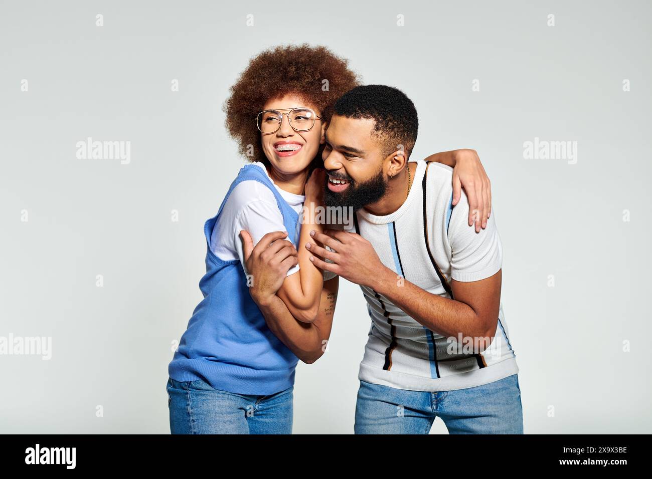 An African American couple in stylish clothes share a warm hug ...