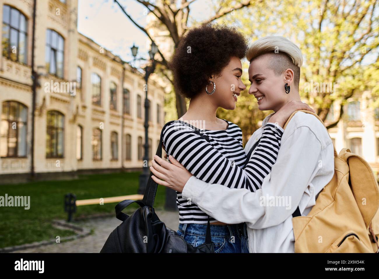 A multicultural lesbian couple hugs affectionately in front of a ...