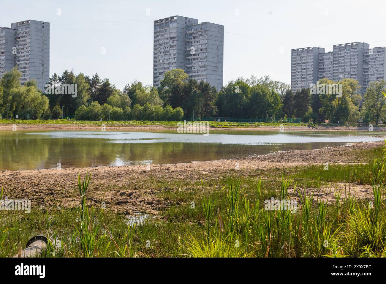 Pipe filling the city pond with water Stock Photo - Alamy