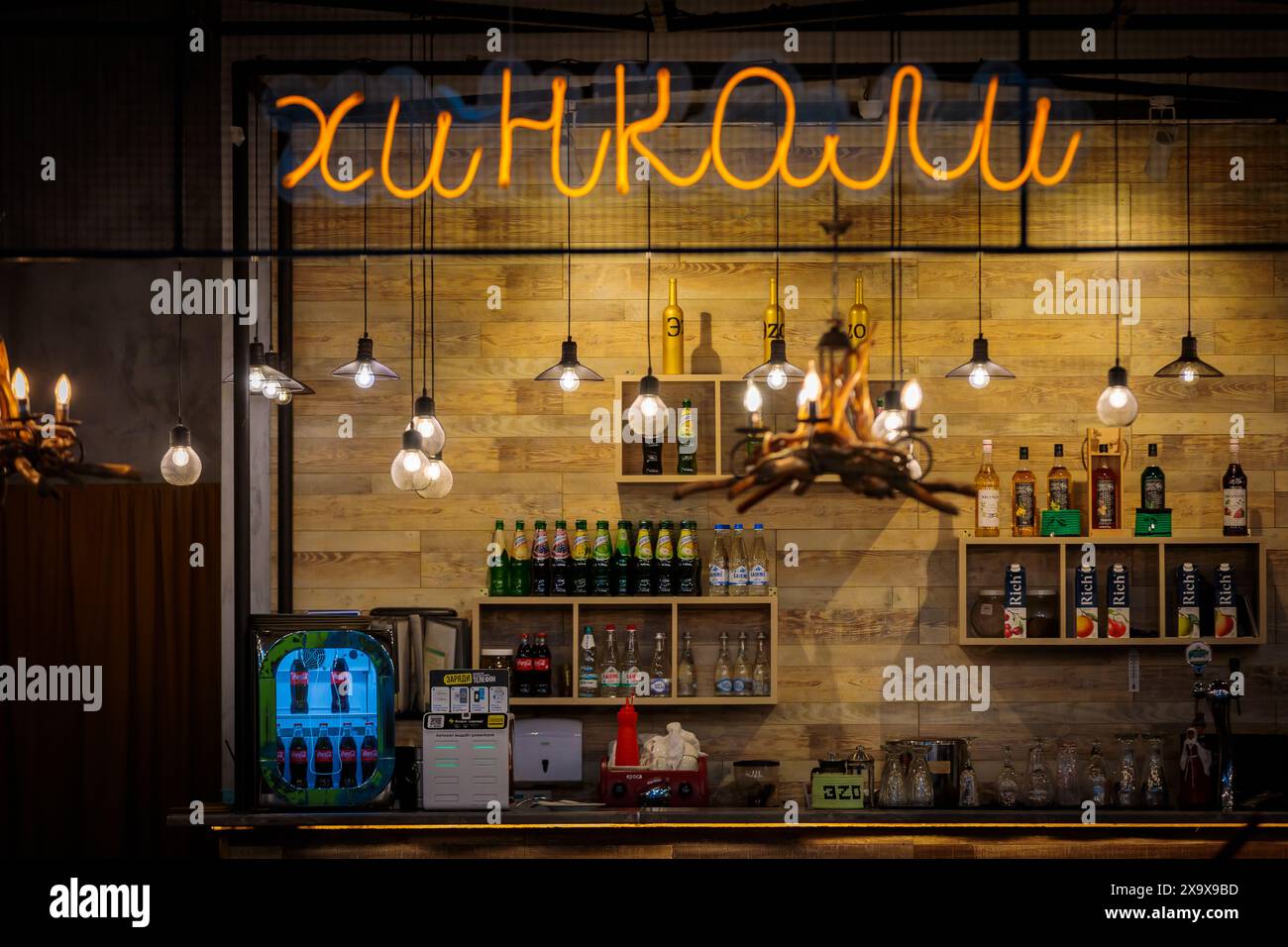A bar counter with bottles of alcoholic beverages and a candle ...