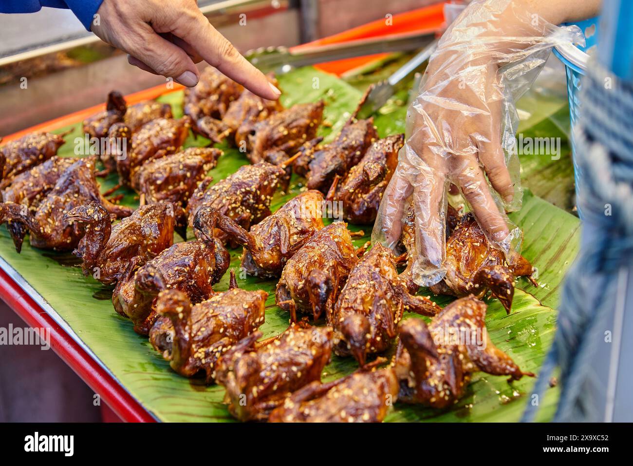 Grilled Quails for sale at street food Stock Photo - Alamy
