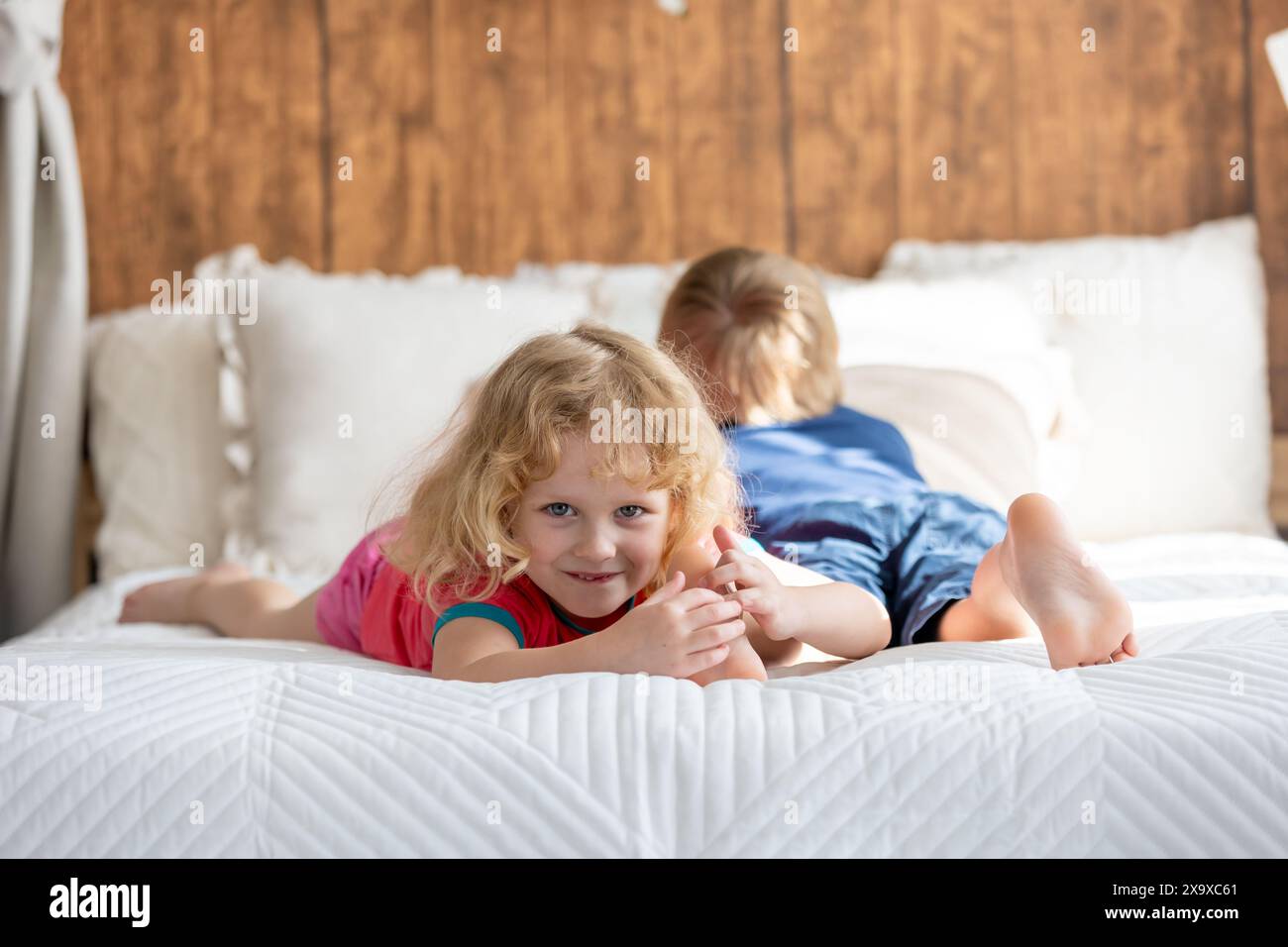 Cute sweet toddler children, tickling feet on the bed, laughing and ...
