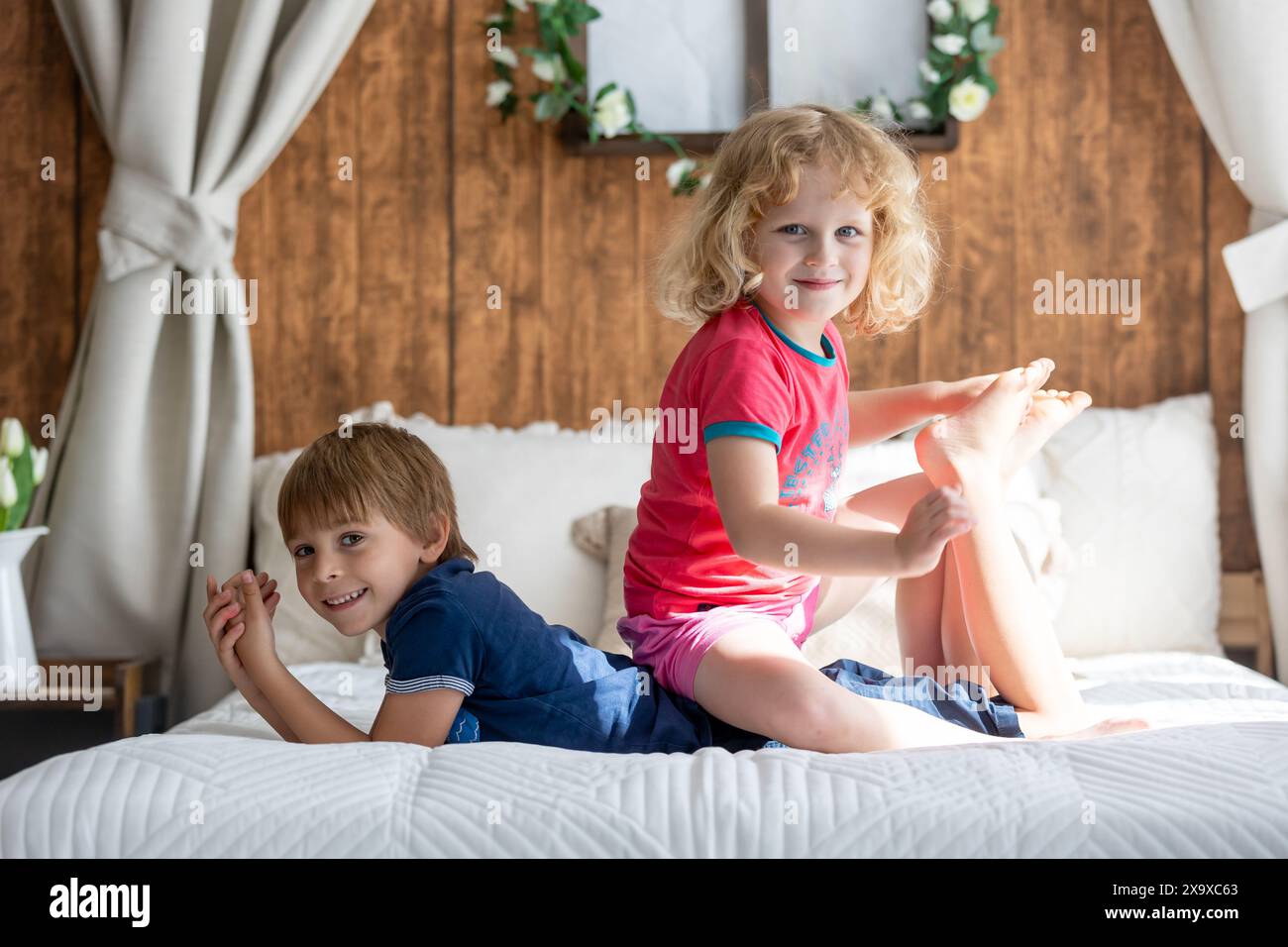 Cute sweet toddler children, tickling feet on the bed, laughing and ...