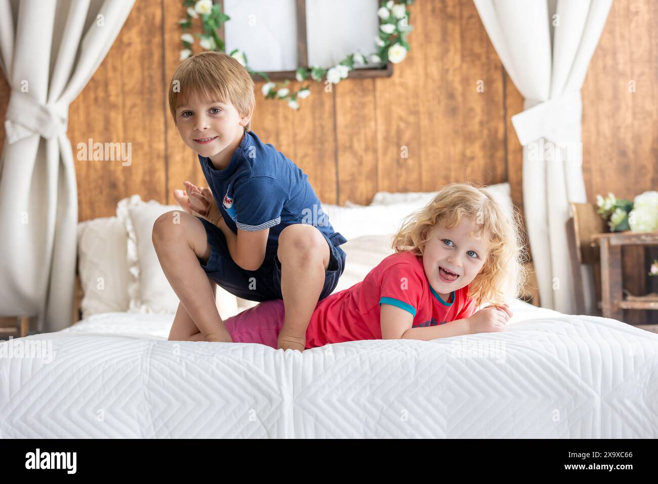 Cute sweet toddler children, tickling feet on the bed, laughing and ...