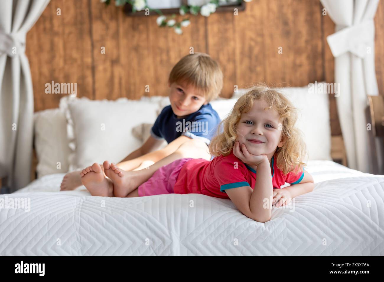 Cute sweet toddler children, tickling feet on the bed, laughing and ...