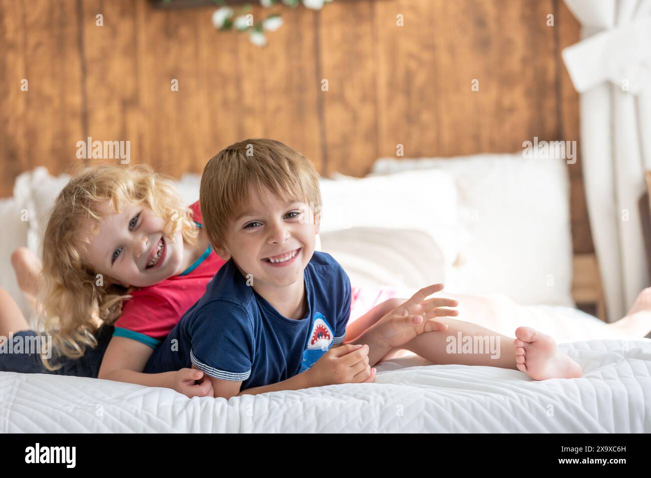 Cute sweet toddler children, tickling feet on the bed, laughing and ...