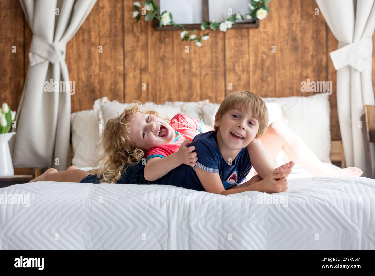 Cute sweet toddler children, tickling feet on the bed, laughing and ...