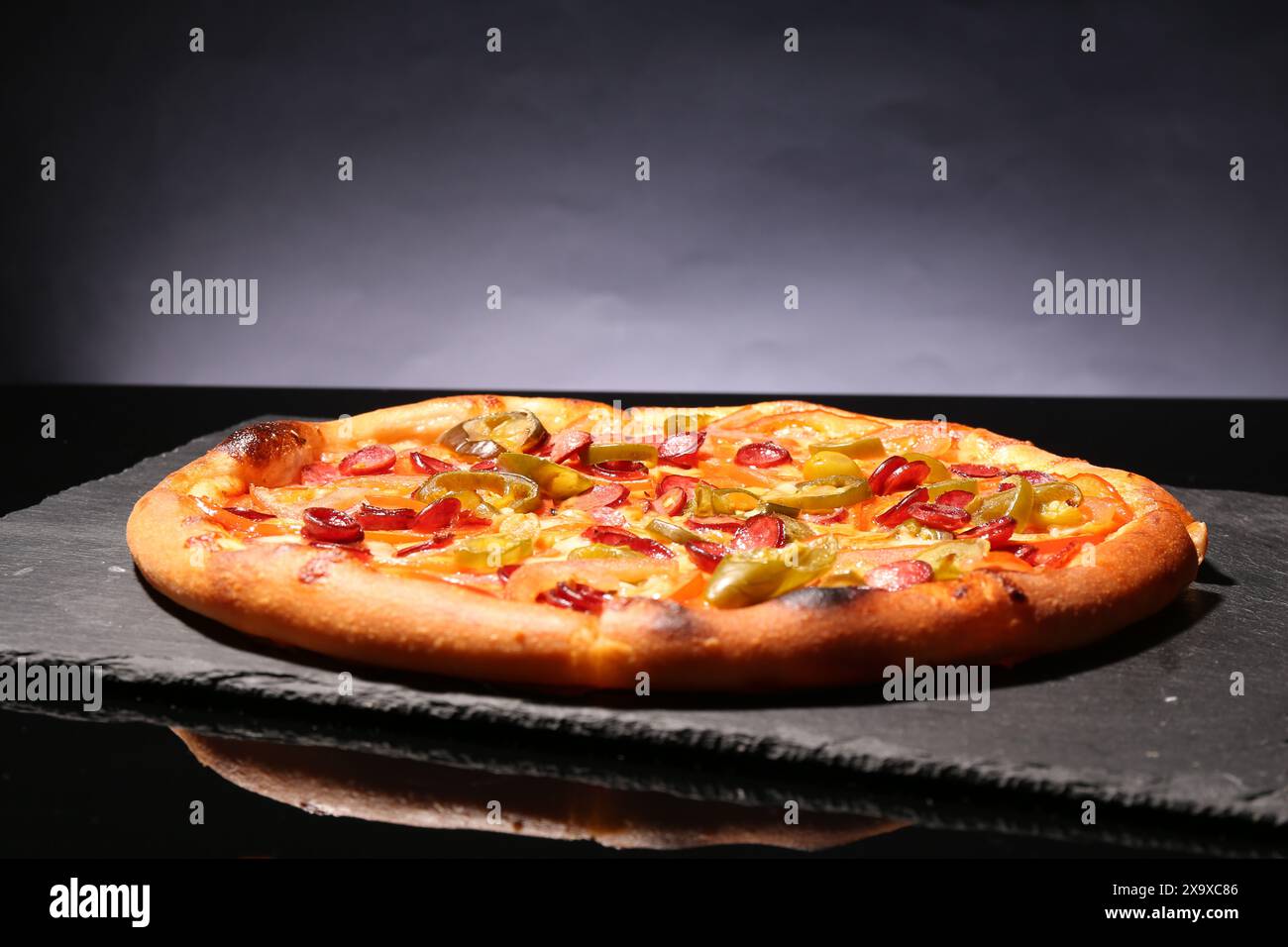 Delicious pizza Diablo on slate board against grey background Stock ...