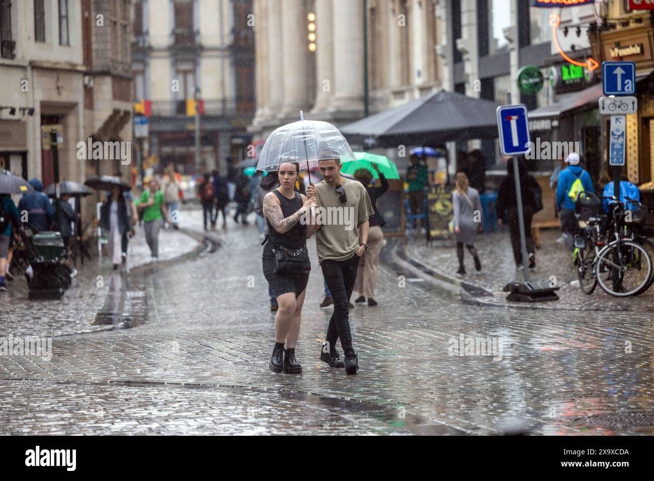 People caught in a heavy rain shower on the streets of Brussels, the ...