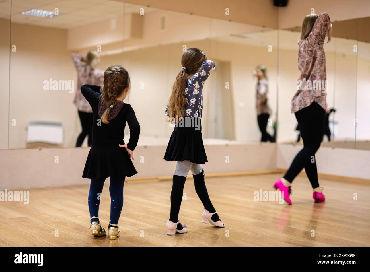 Children learning dance in a studio with an instructor leading the ...