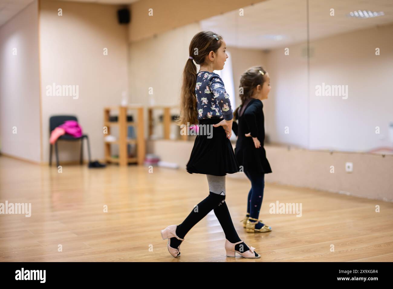 Two young girls practicing ballet in a dance studio, focusing on their ...