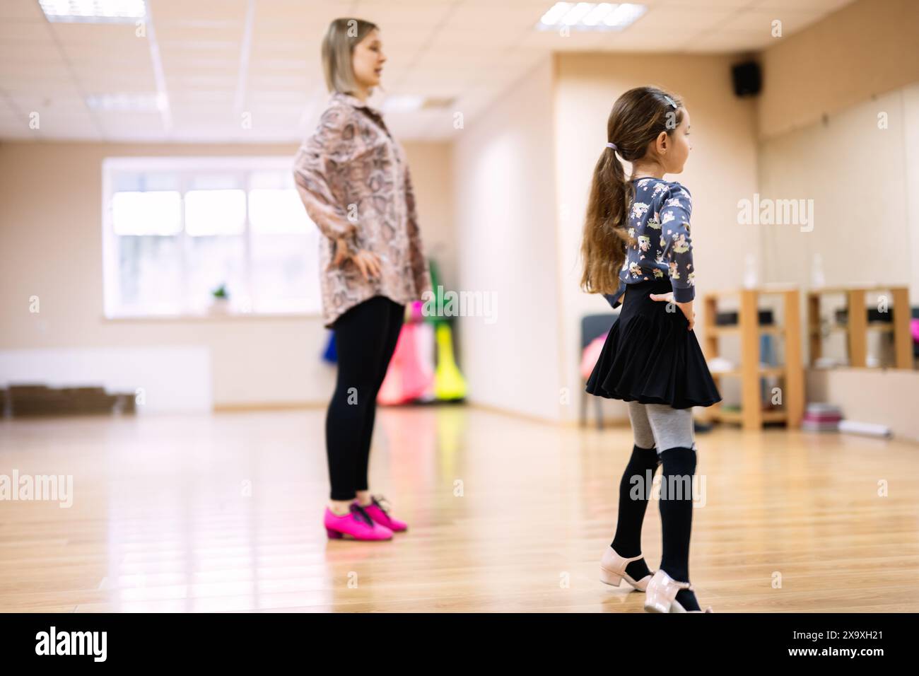 Young girl learning dance moves with instructor in a dance studio ...