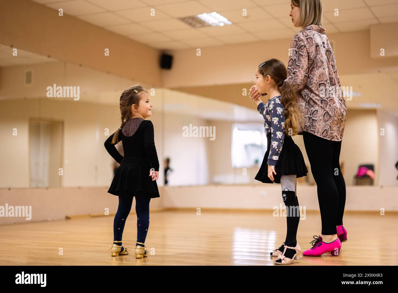 Young girls learning new dance steps from their instructor in a ...