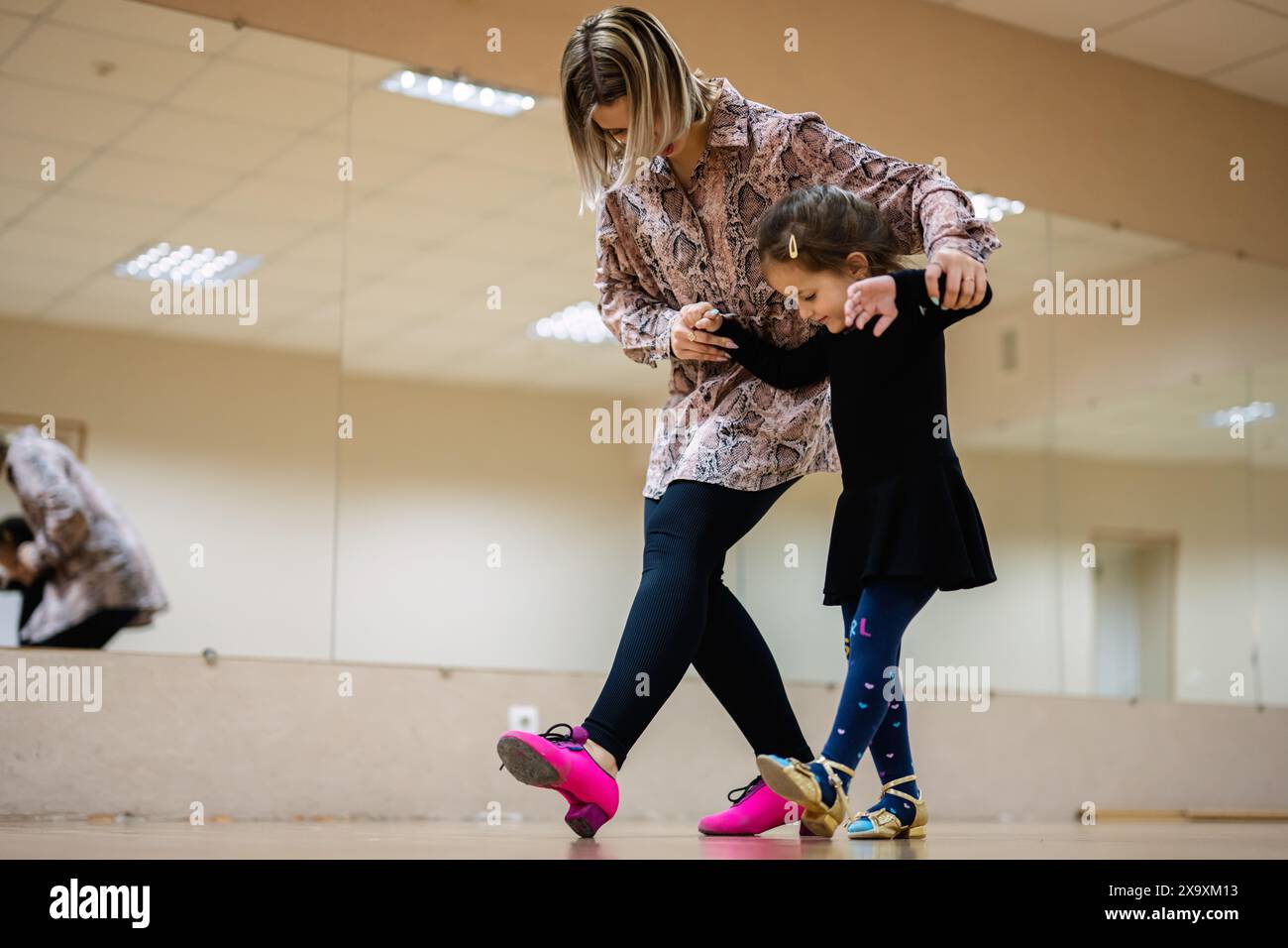 Mother dancing with her daughter in a studio, sharing a precious moment ...