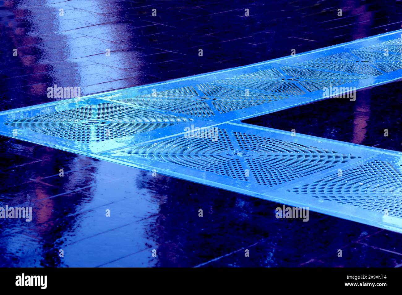 Wet tiled pavement floor with sewer metal gratings for water drainage ...