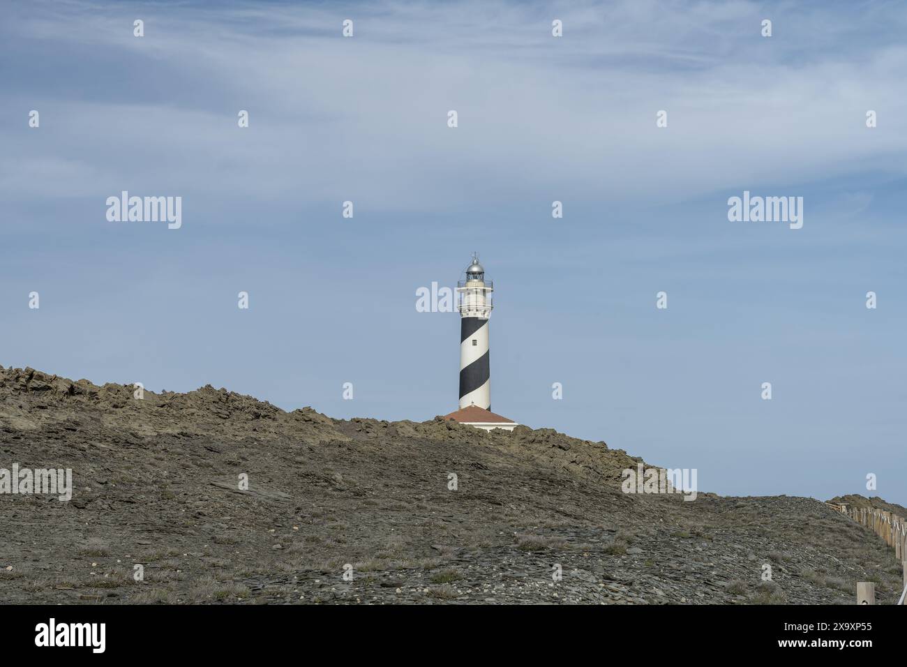 A scenic view of the Faro de Favaritx lighthouse in Menorca, featuring ...