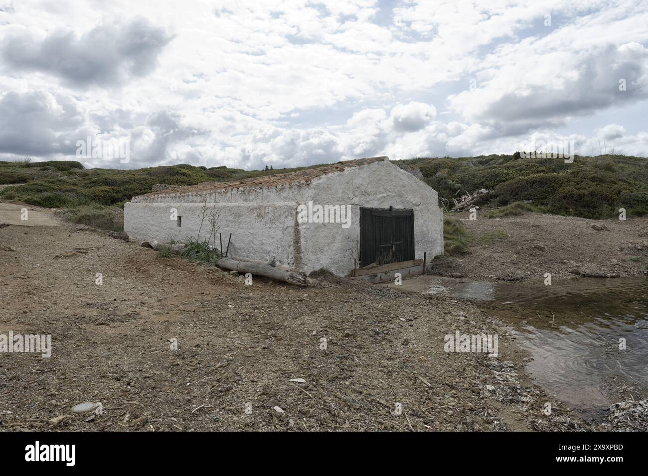 A rustic whitewashed building with a tiled roof at Port of Sanitja ...
