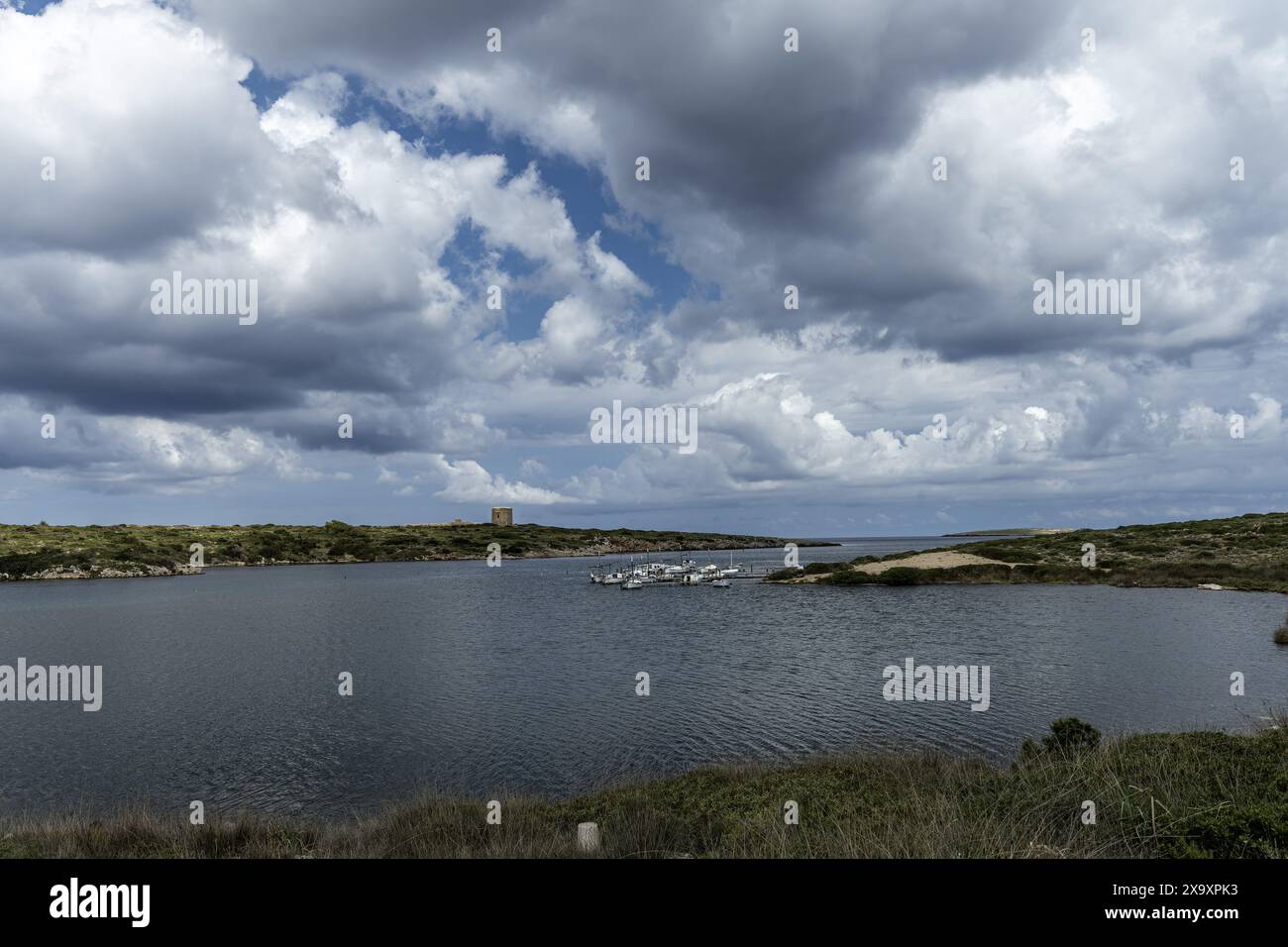 A picturesque scene at Port of Sanitja, Menorca, with boats anchored in ...
