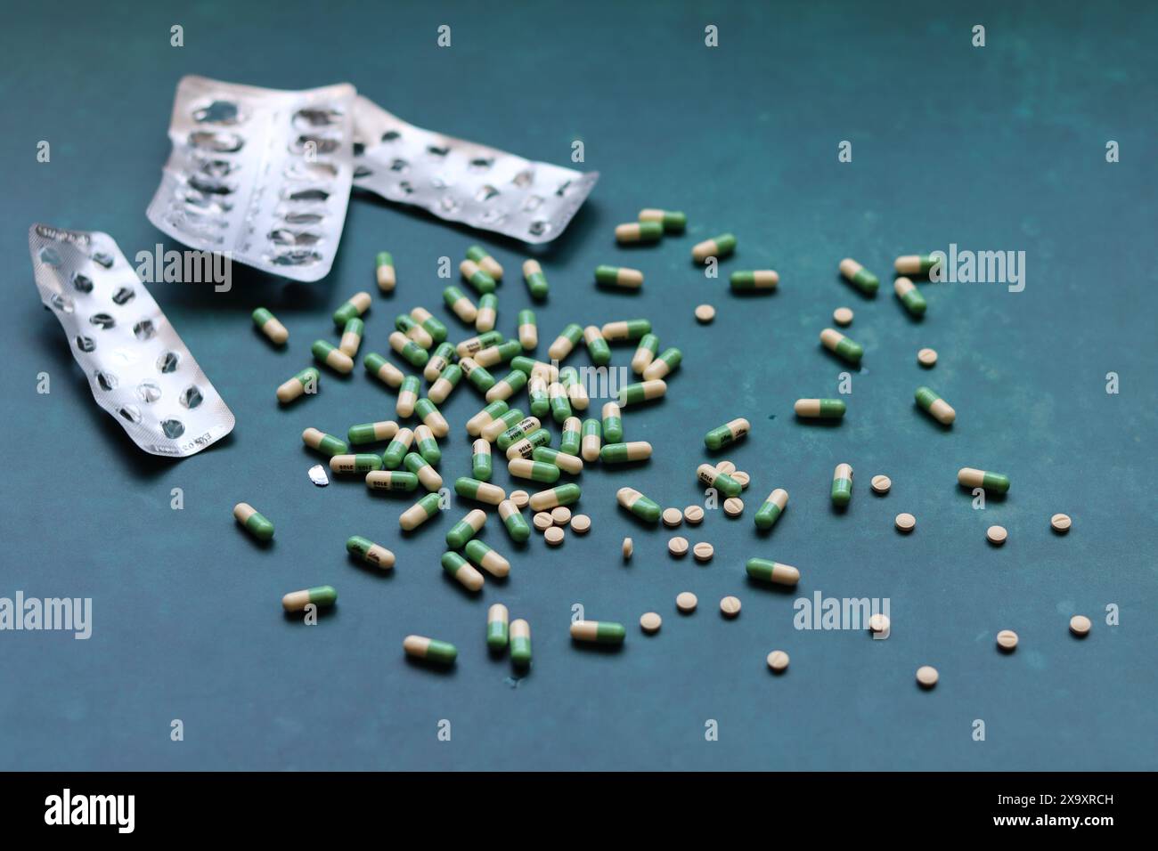 Pharmaceutical pills and capsules against textured blue background with ...