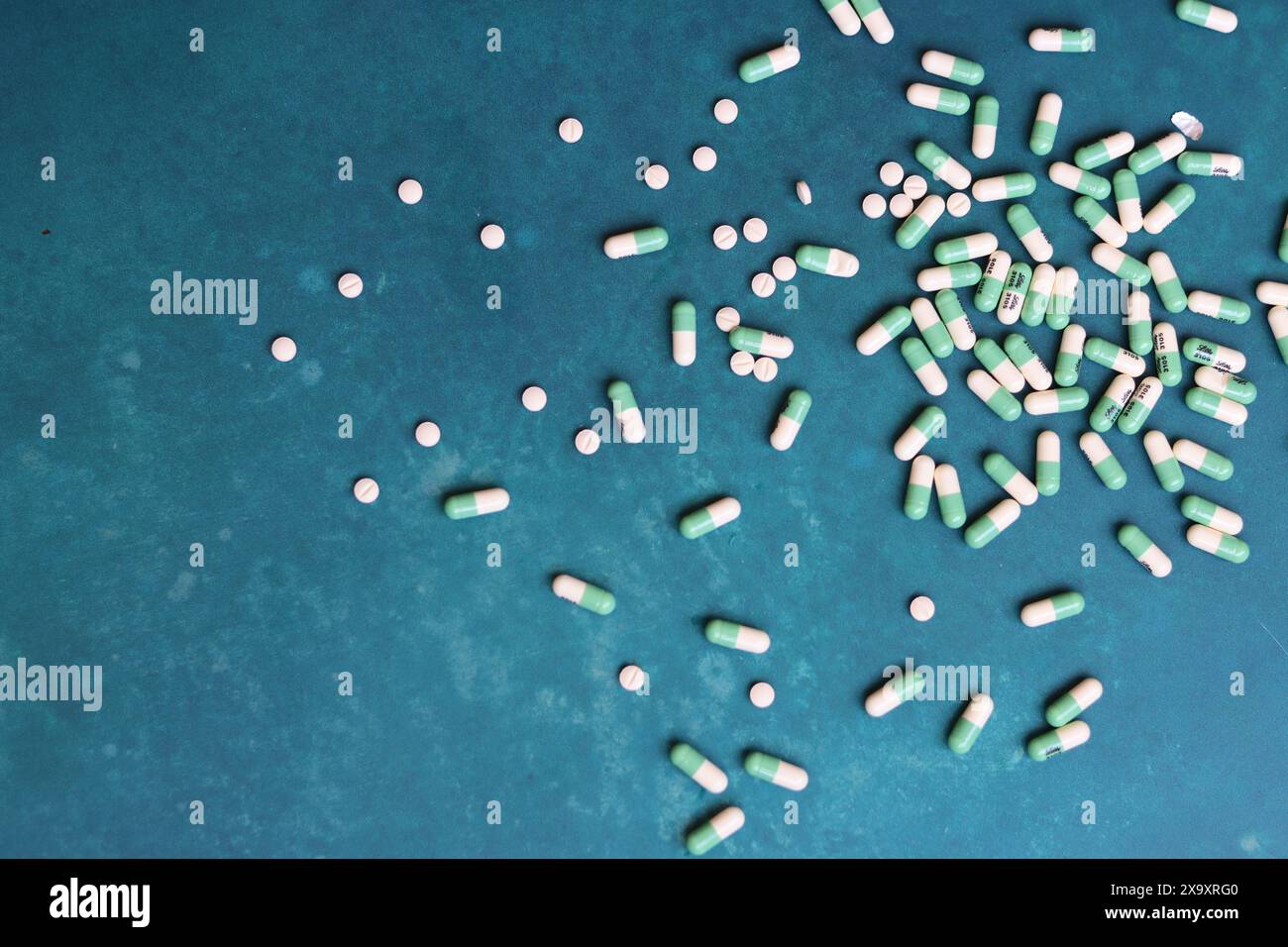 Pharmaceutical pills and capsules against textured blue background with ...