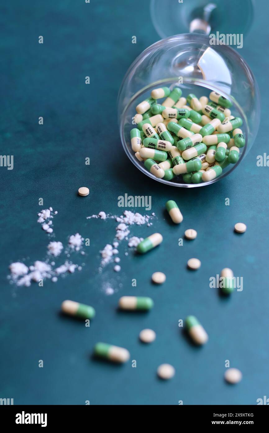 Pharmaceutical pills and capsules against textured blue background with ...