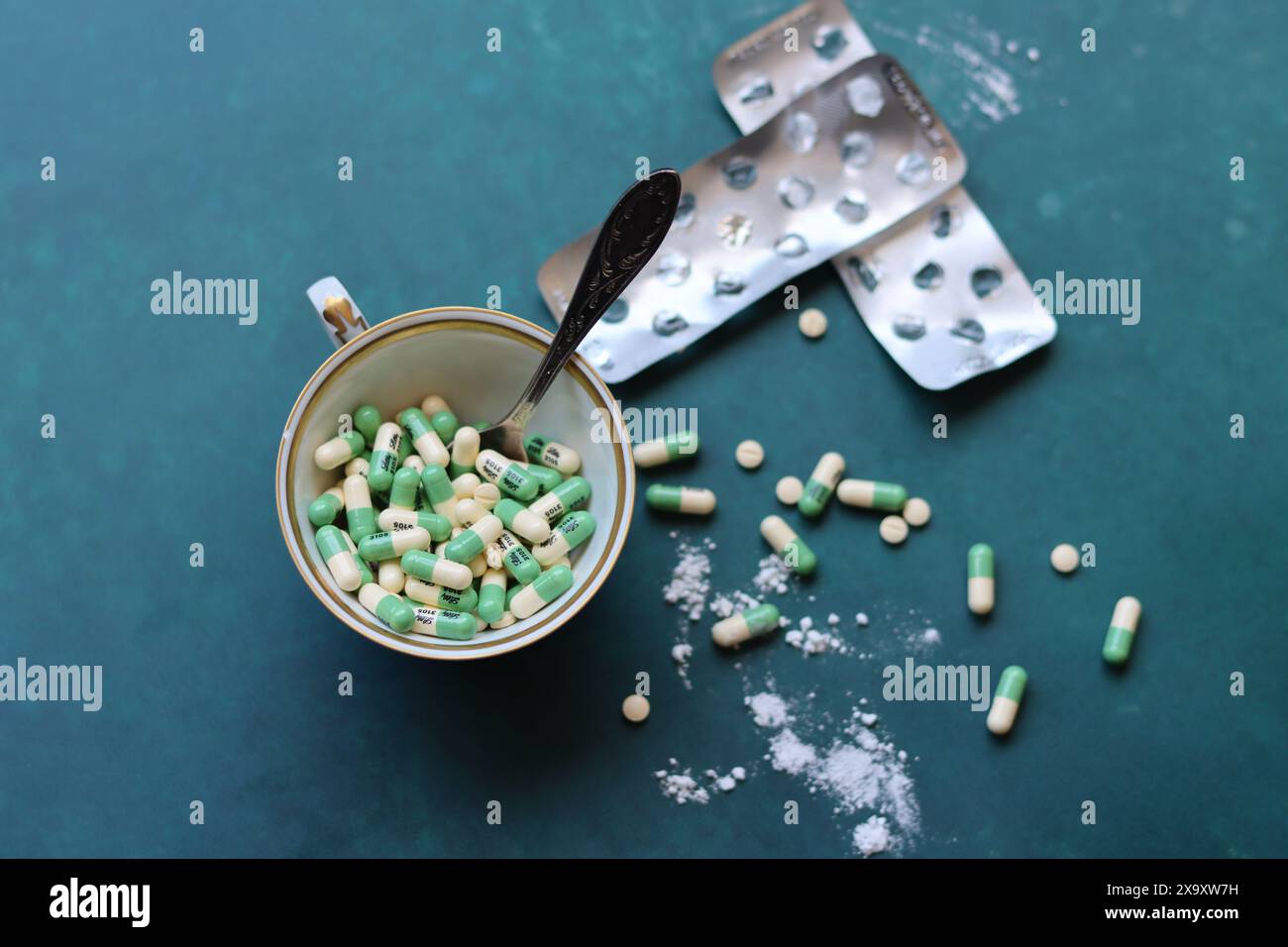 Pharmaceutical pills and capsules against textured blue background with ...