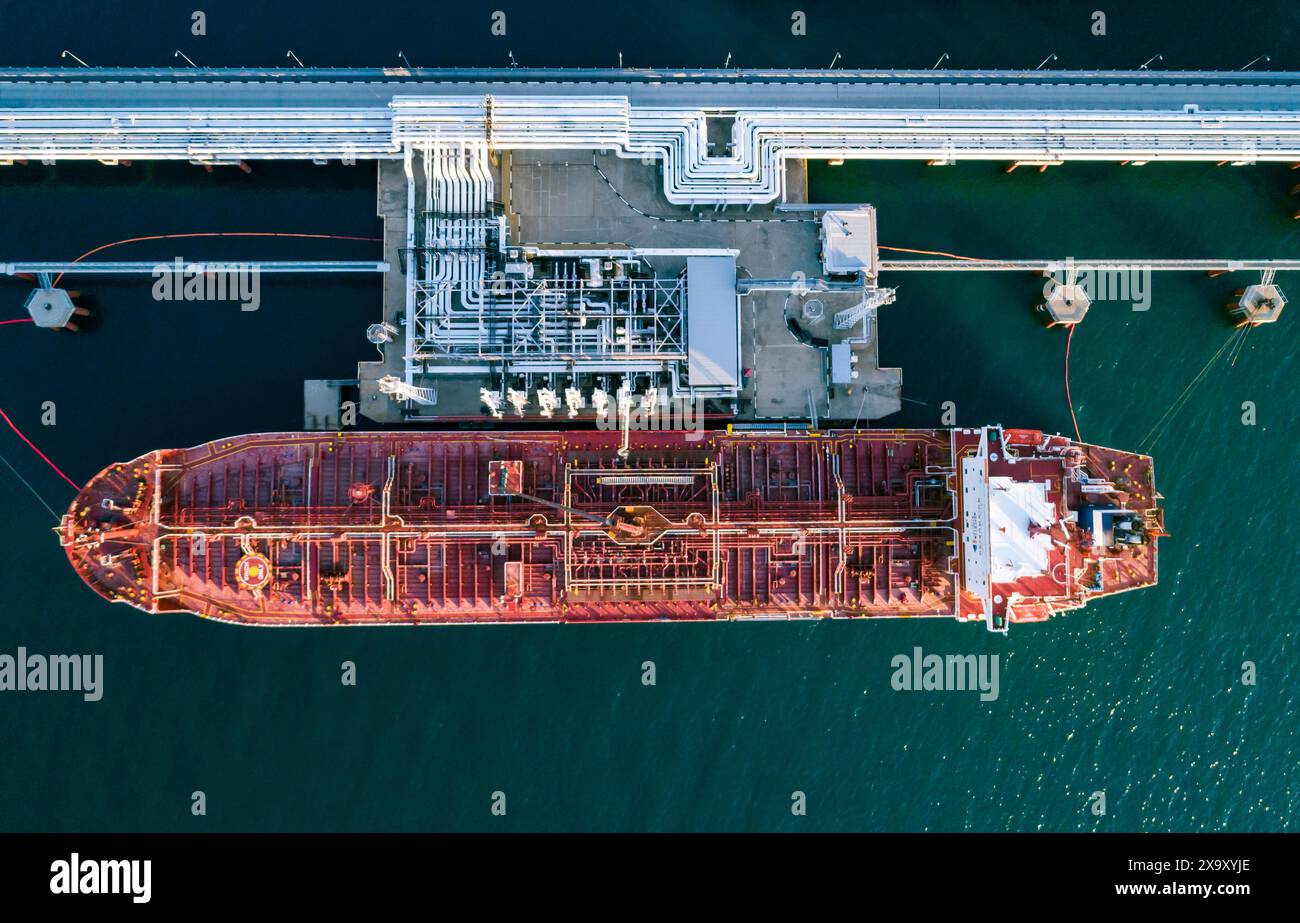 Aerial top down view of a large oil tanker docked at a pier in the port ...