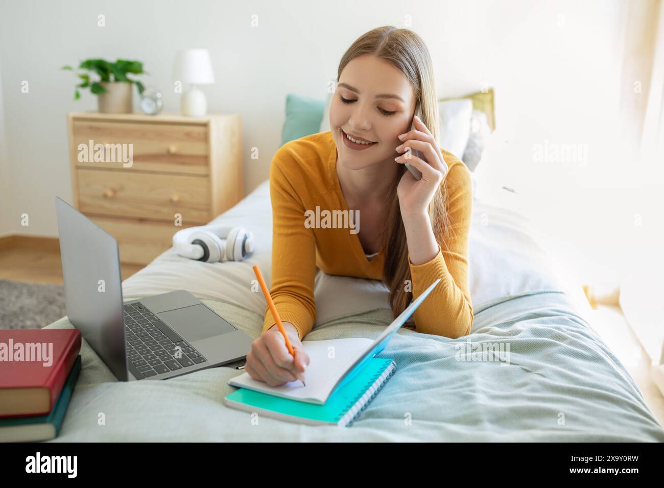 Girl Working From Home on Bed With Laptop and Notebook Stock Photo - Alamy