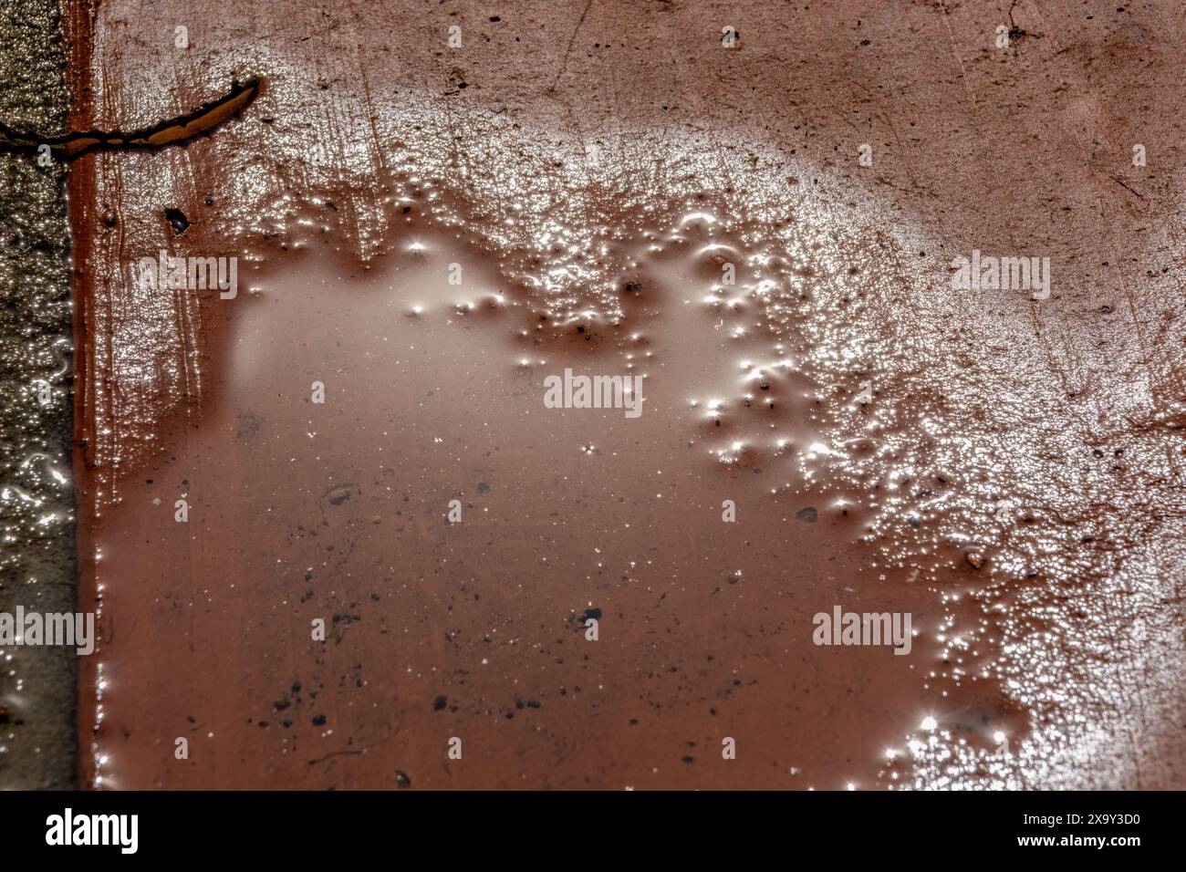 The reflections of the morning sun in a rain puddle on a traditional ...