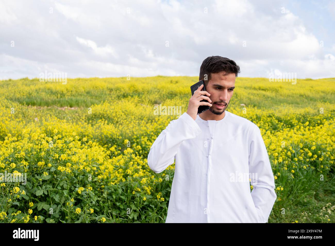 young arabic male making phone call during vacation in park, working ...