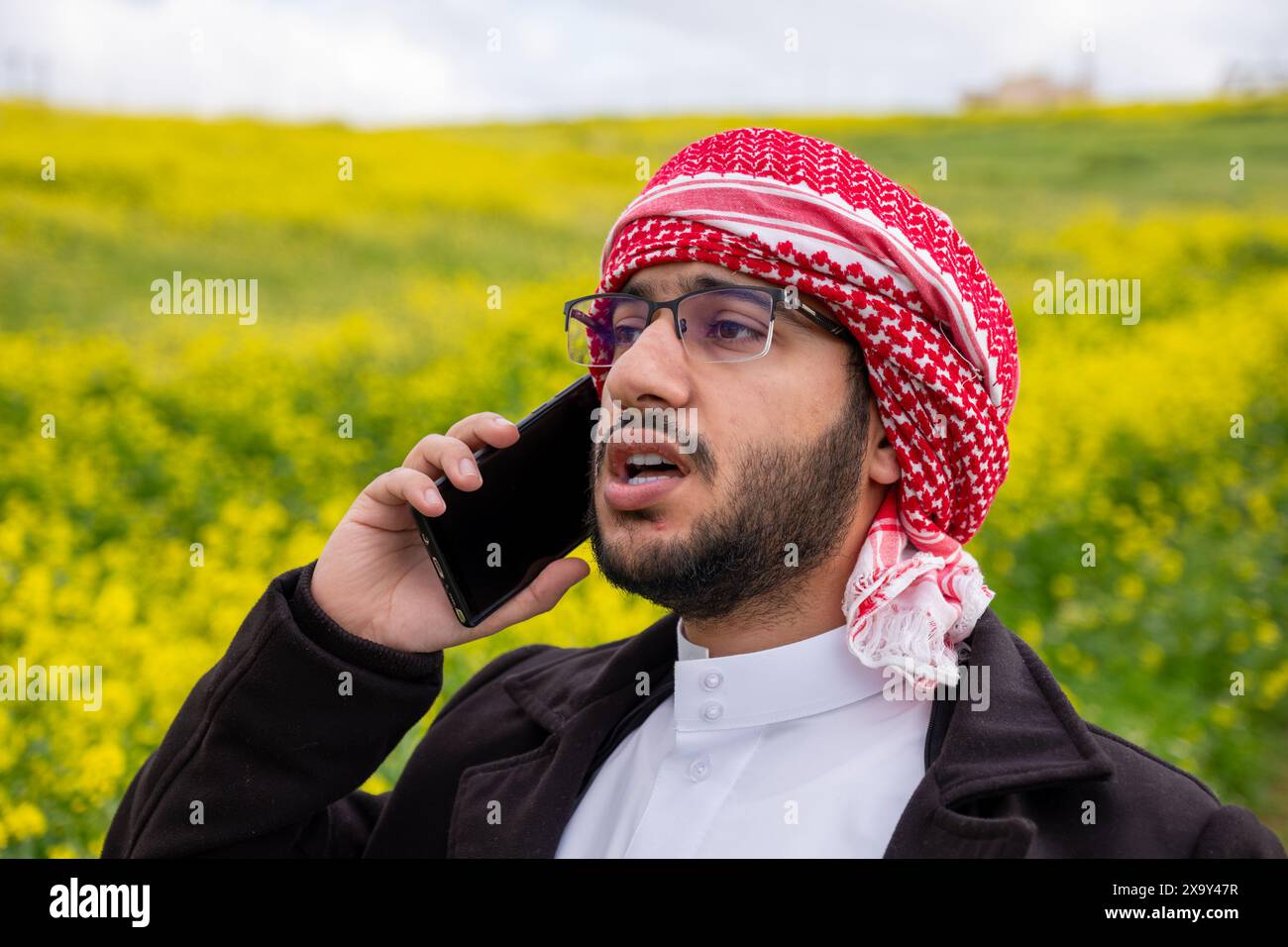 young arabic male making phone call during vacation in park, working ...