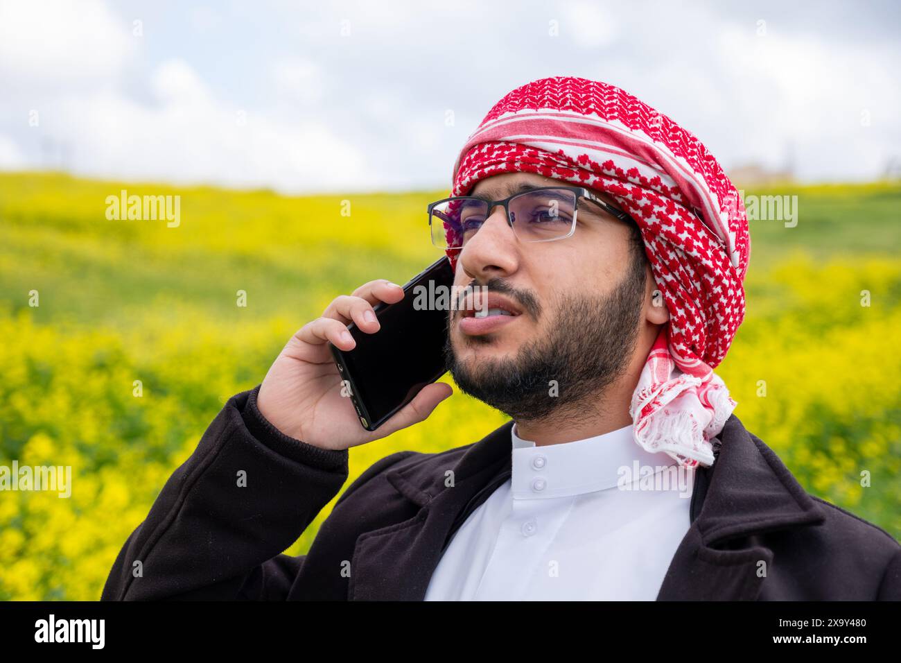 young arabic male making phone call during vacation in park, working ...