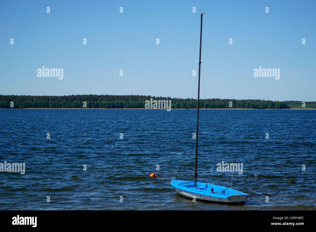 Blue yacht without sails at lake shore Stock Photo - Alamy