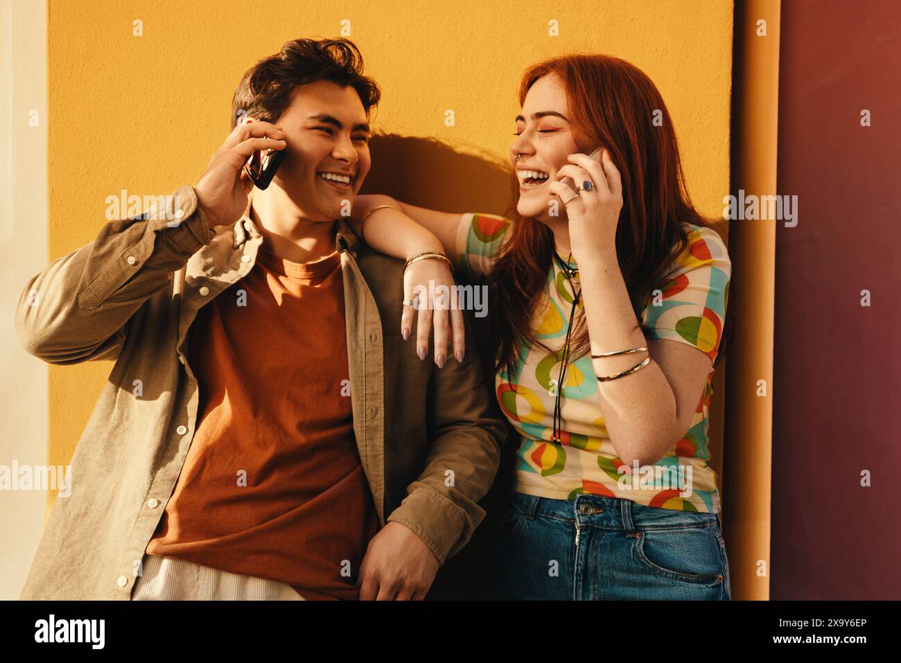 Two friends share a fun moment talking on the phone, laughing together ...