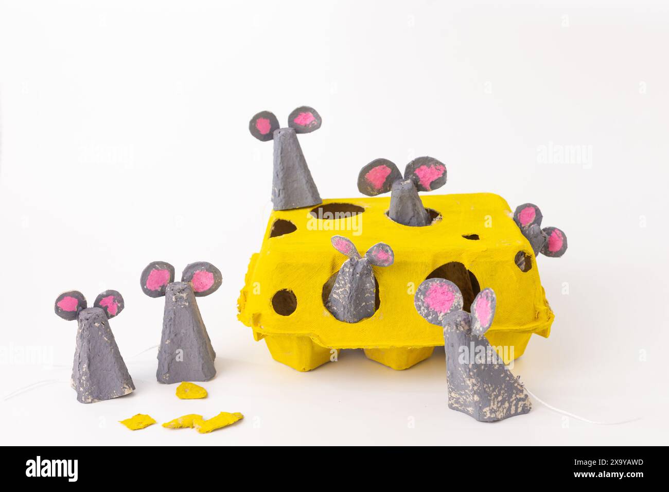 Yellow egg carton creatively repurposed as cheese with mouse figurines ...